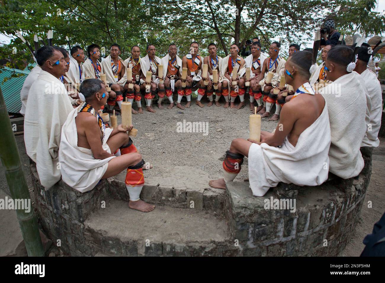 Naga tribal men in traditional attire drink rice beer before a dance ...