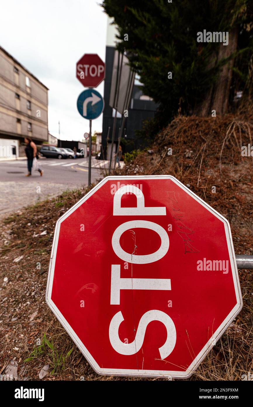 Stop red sign is laying down on the grounds in a urban scene, more ...