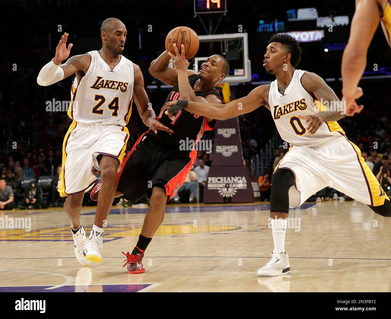 Toronto Raptors' Kyle Lowry, center, is defended by Los Angeles Lakers ...