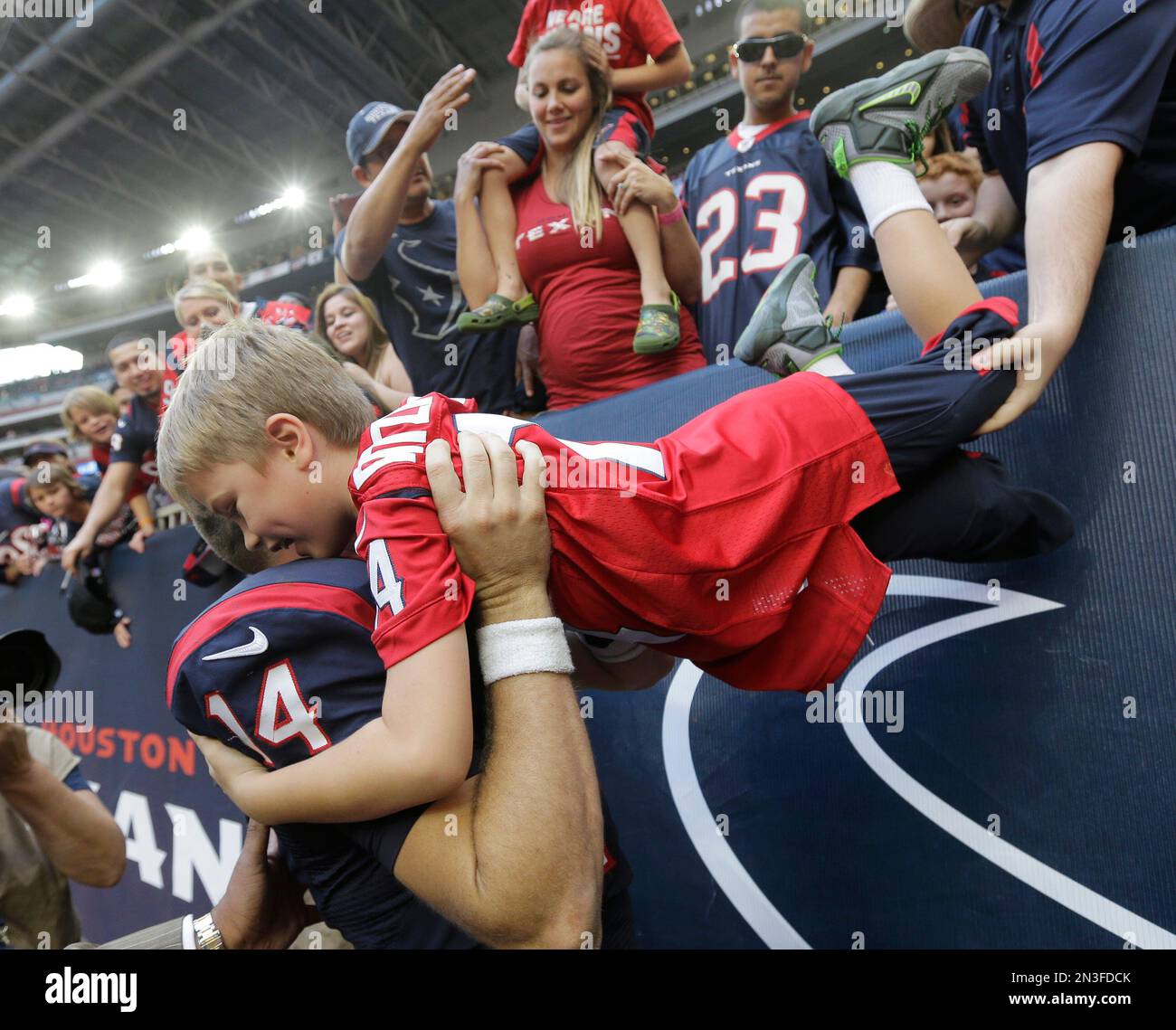 Houston Texans' Ryan Fitzpatrick (14) grabs is children from the stands ...