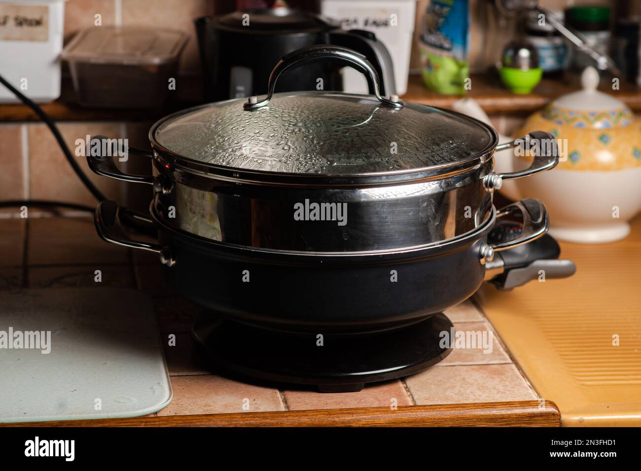 Saucepan electric steamer on the kitchen table. A metal modern device ...