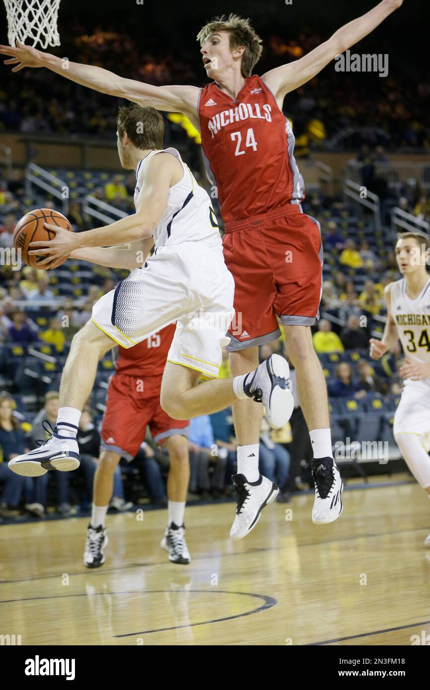 Michigan guard Spike Albrecht passes around the defense of Nicholls ...