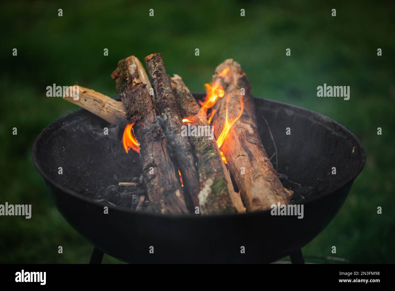 The smoking brazier of a round form. Firewood flares up in the brazier ...