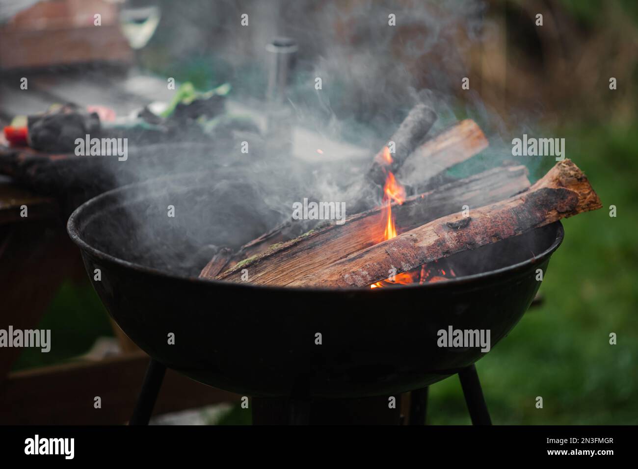 The smoking brazier of a round form. Firewood flares up in the brazier ...