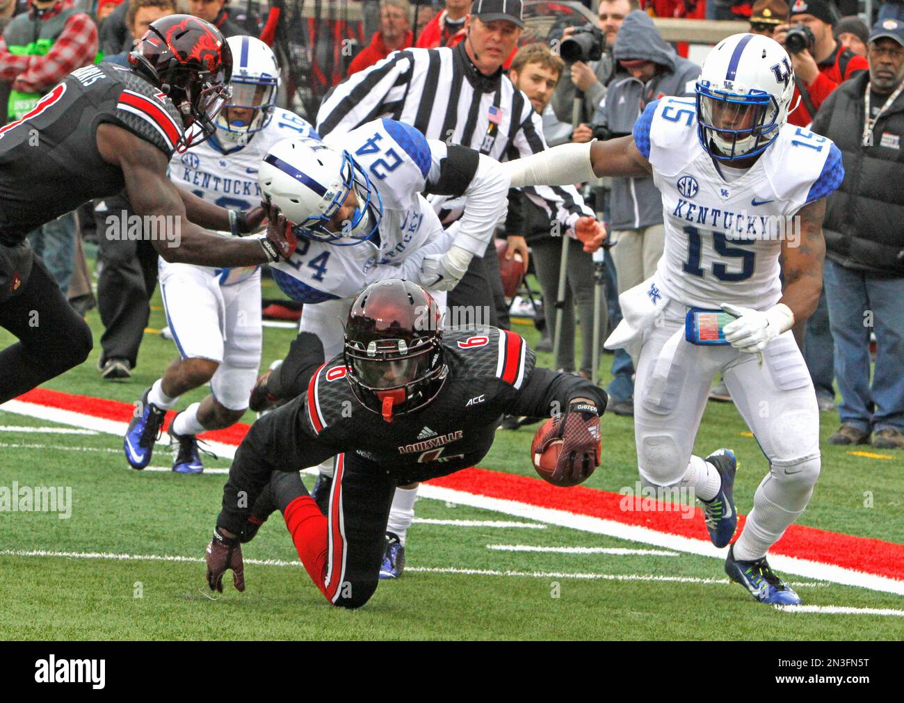 Louisville's Eli Rogers, bottom, lunges forward as Kentucky's Marcus ...