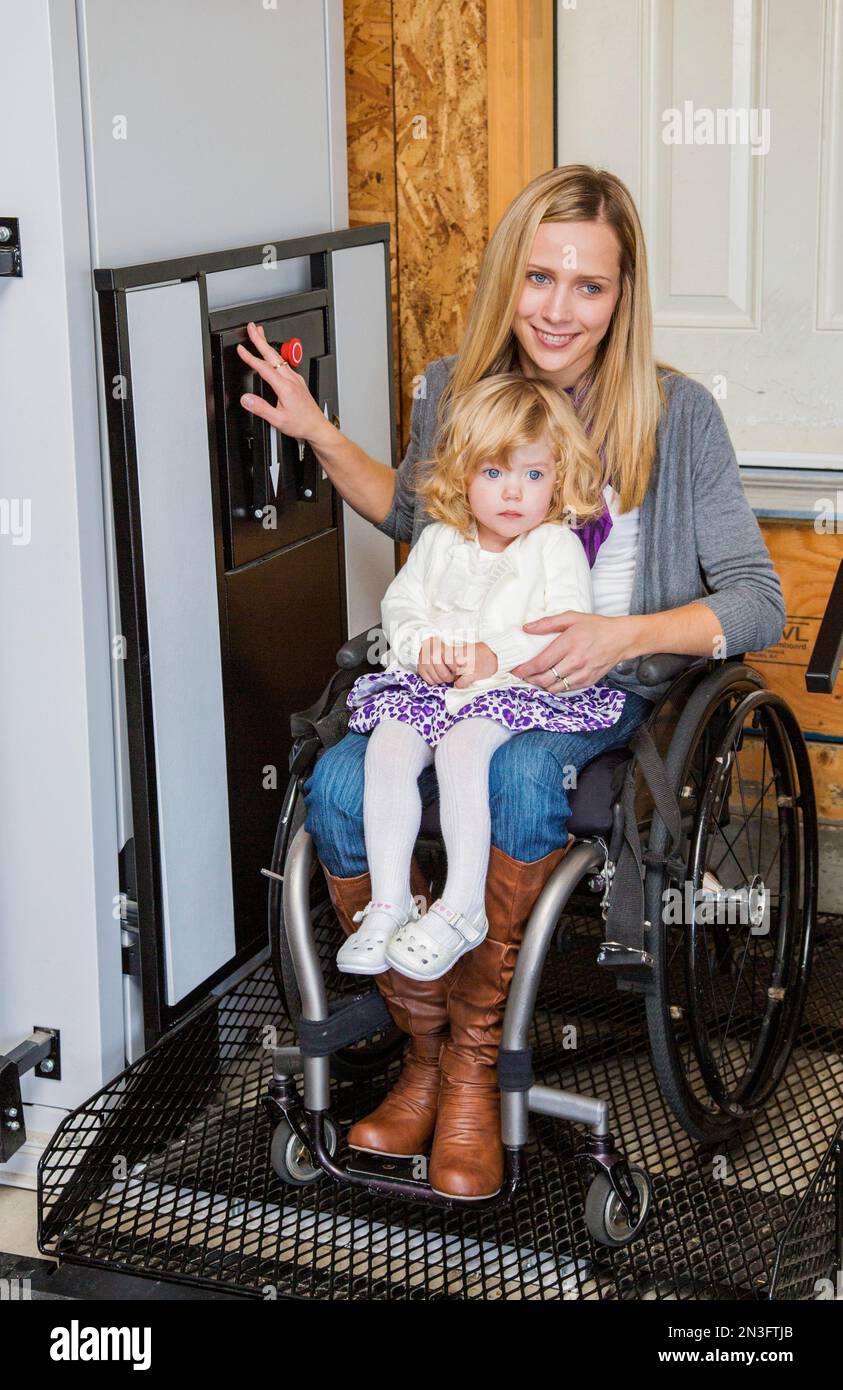 Young disabled mother with her daughter using a wheelchair powered ...