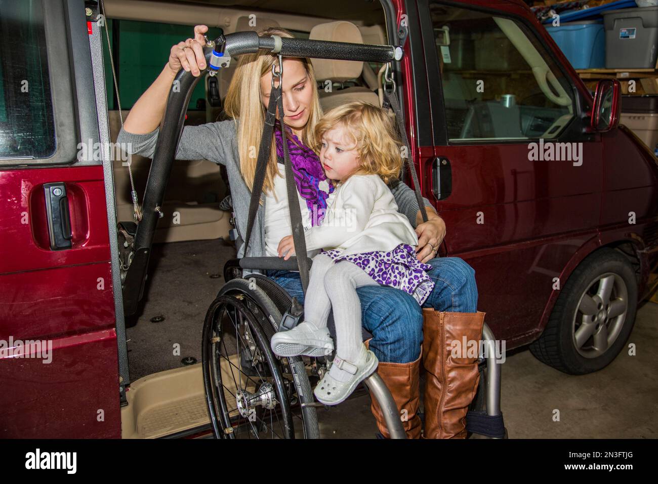 Young disabled mother with her daughter using a wheelchair powered ...