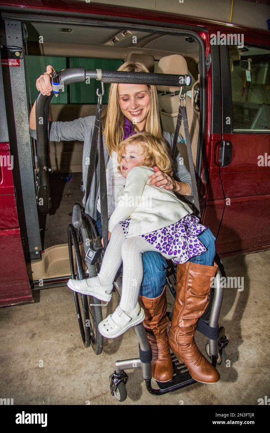 Young disabled mother with her daughter using a wheelchair powered ...