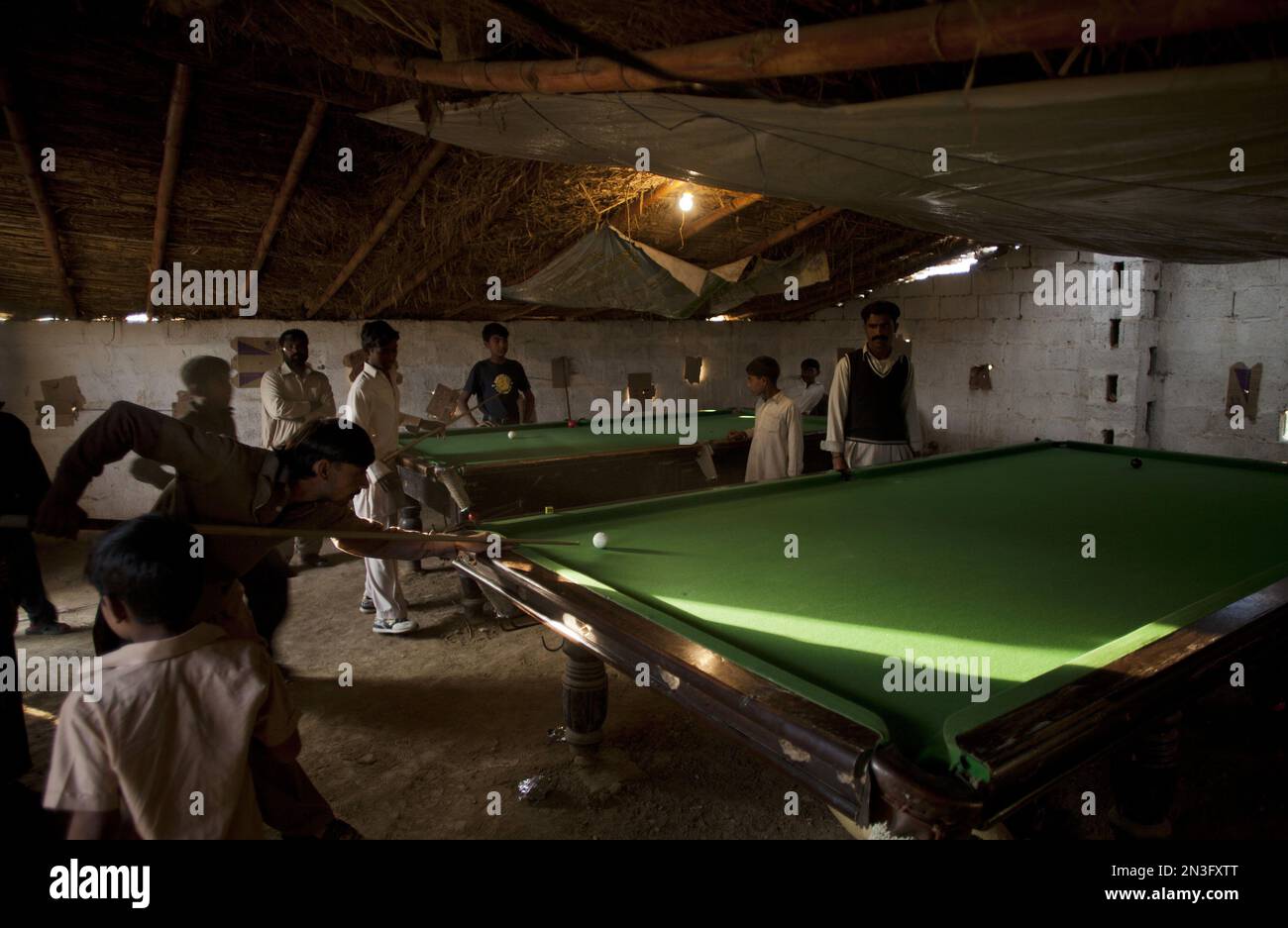 Pakistani men play billiards in a makeshift club in Islamabad's slums ...