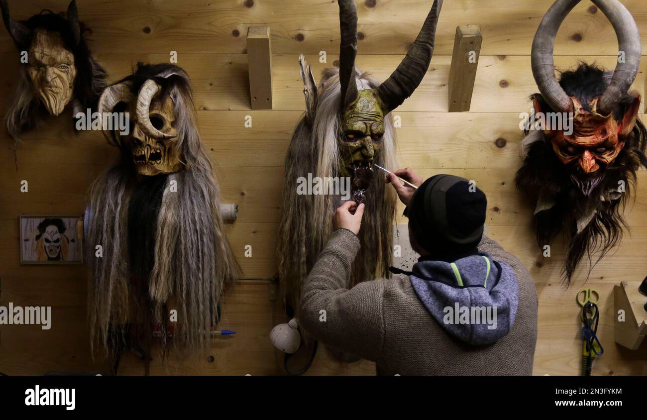 Wood carver Hans Schwabl (26) paints at a traditional wooden Perchten ...