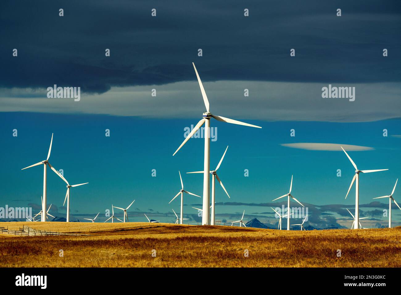Large metal wind turbines in a rolling stubble field with Chinook arc ...