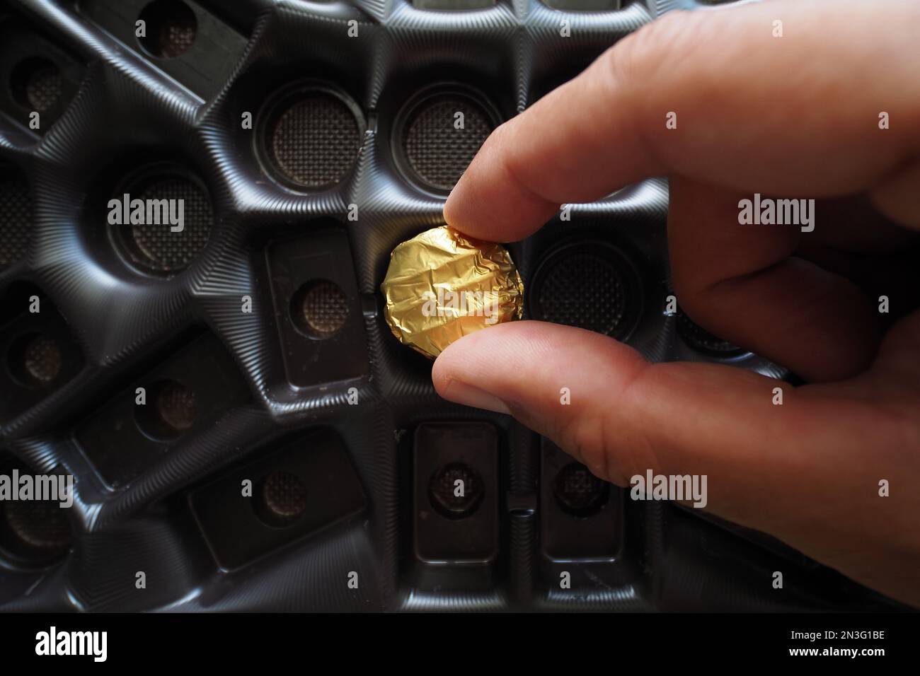 Take last candy in gold package Stock Photo - Alamy