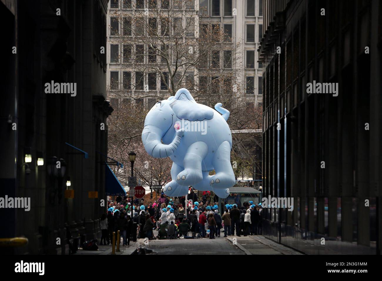 The Horton the Elephant balloon passes an alleyway as handlers walk it ...