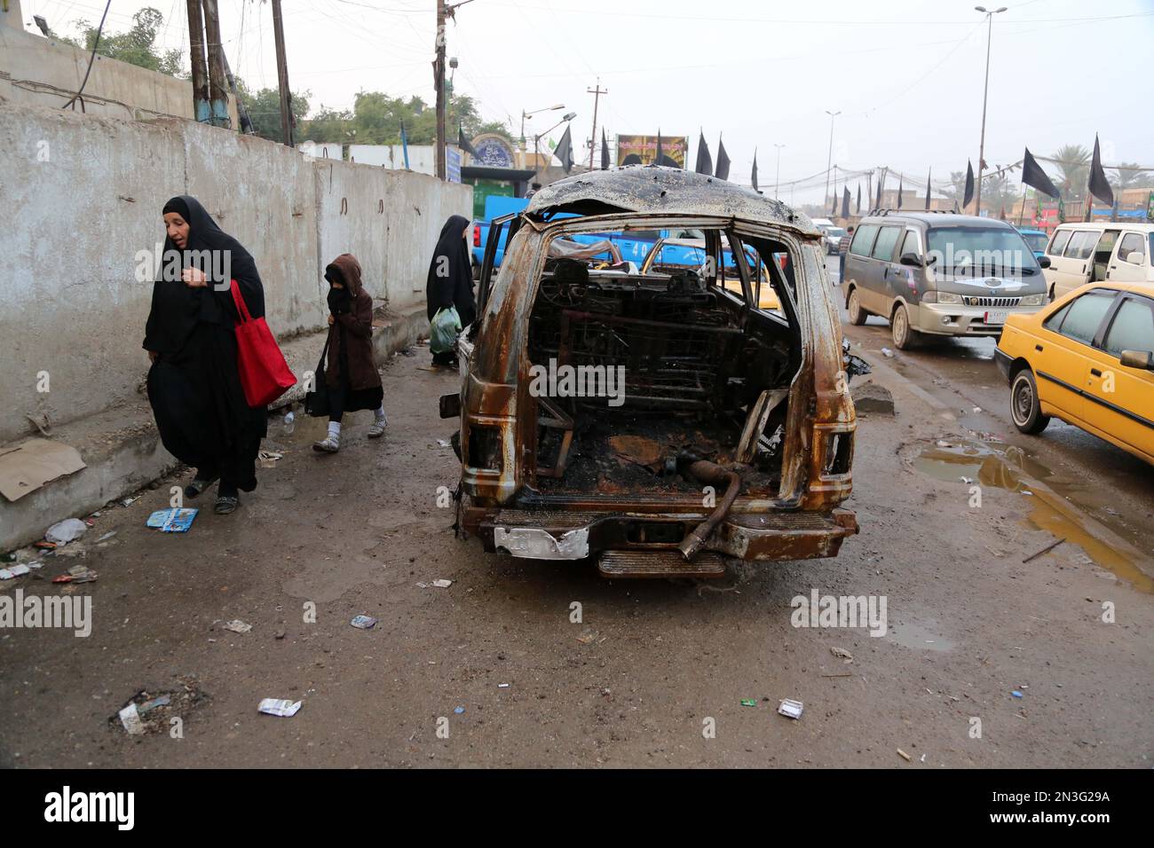 People inspect the site of Wednesday's car bomb explosion, in Baghdad ...