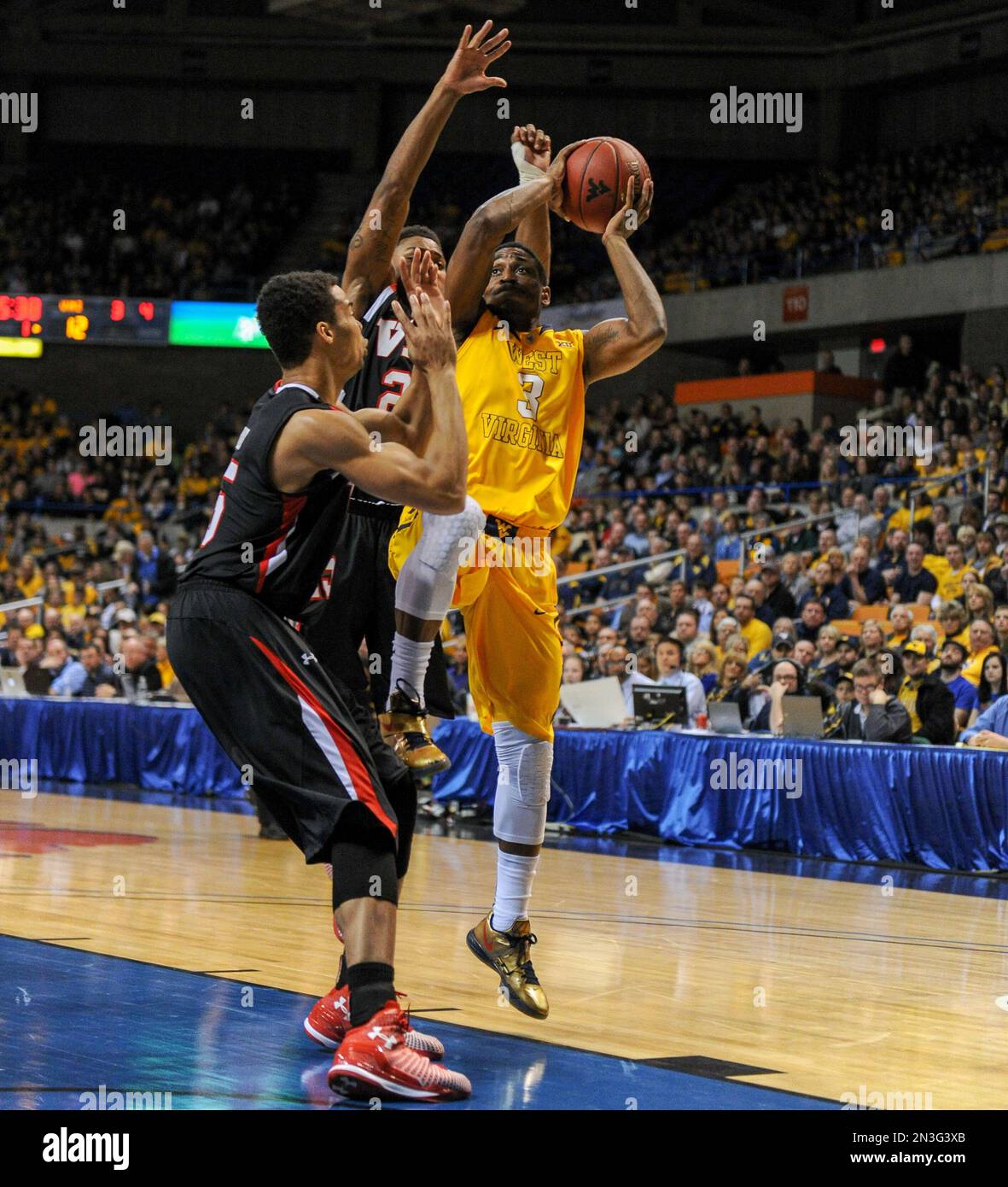West Virginia's Juwan Staten (3) shoots as VMI's Craig Hinton (25 ...