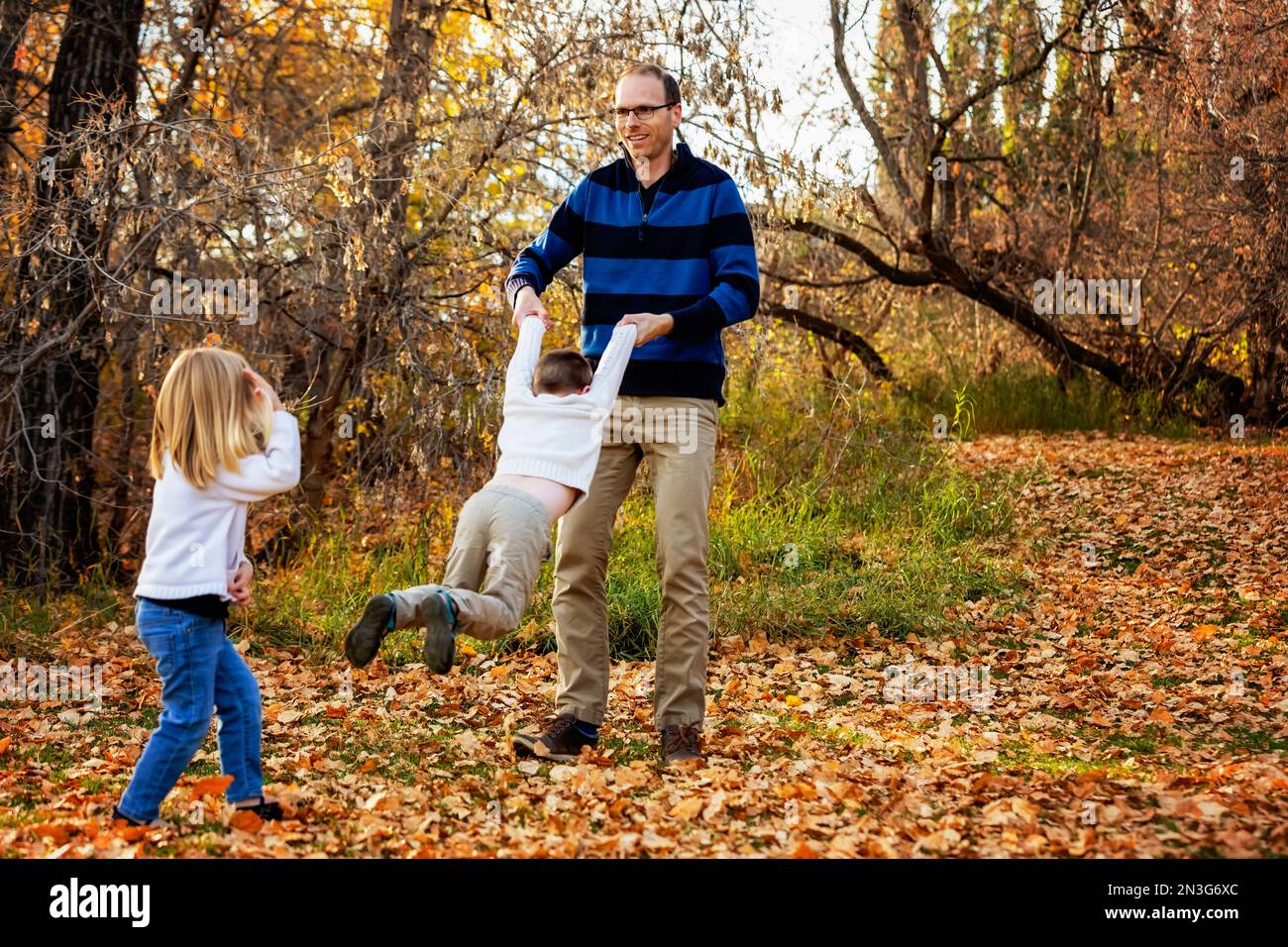 A father swinging his son around and spending quality time with his ...