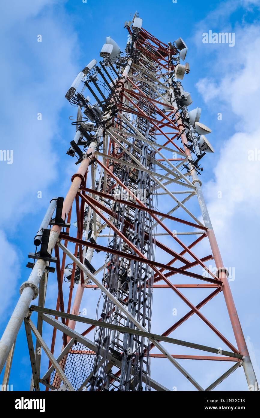 Telecommunication tower with blue and white clouds sky. Low angle view Stock Photo - Alamy
