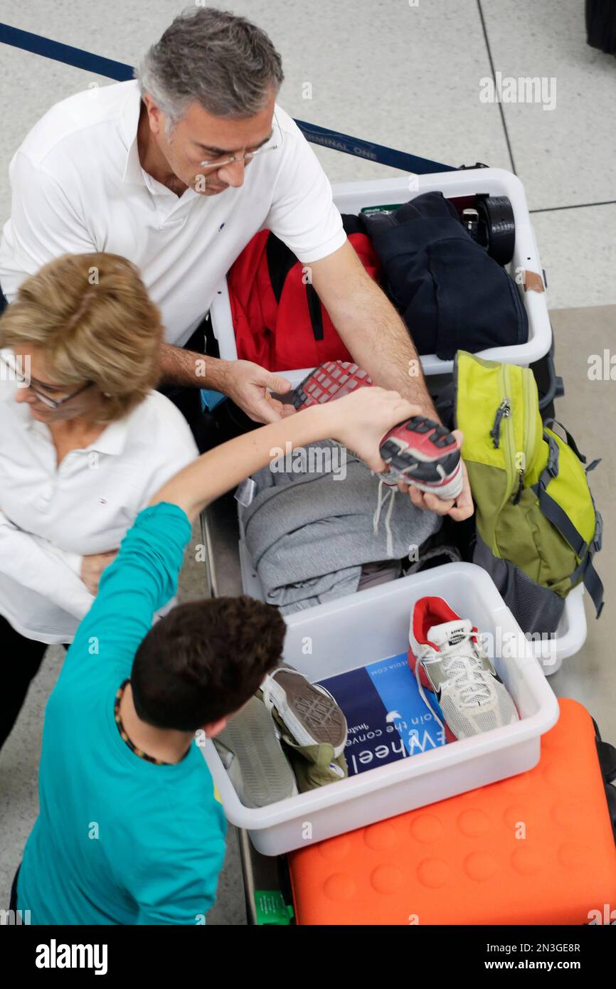 Passengers remove their shoes and other items and place them in plastic ...