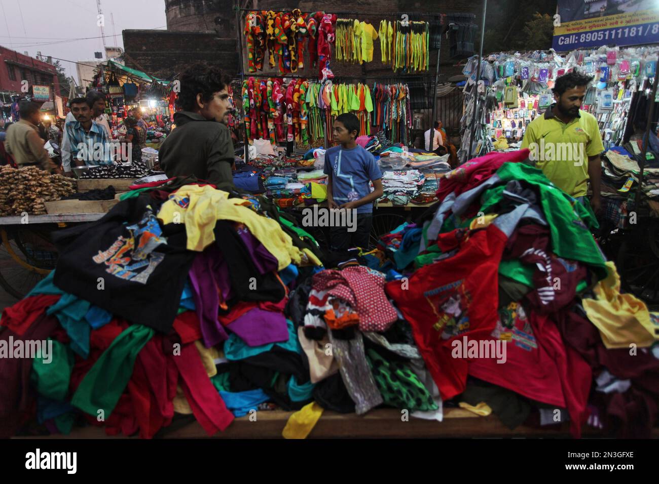 Indian vendors await customers at a market in Ahmadabad, India, Monday ...