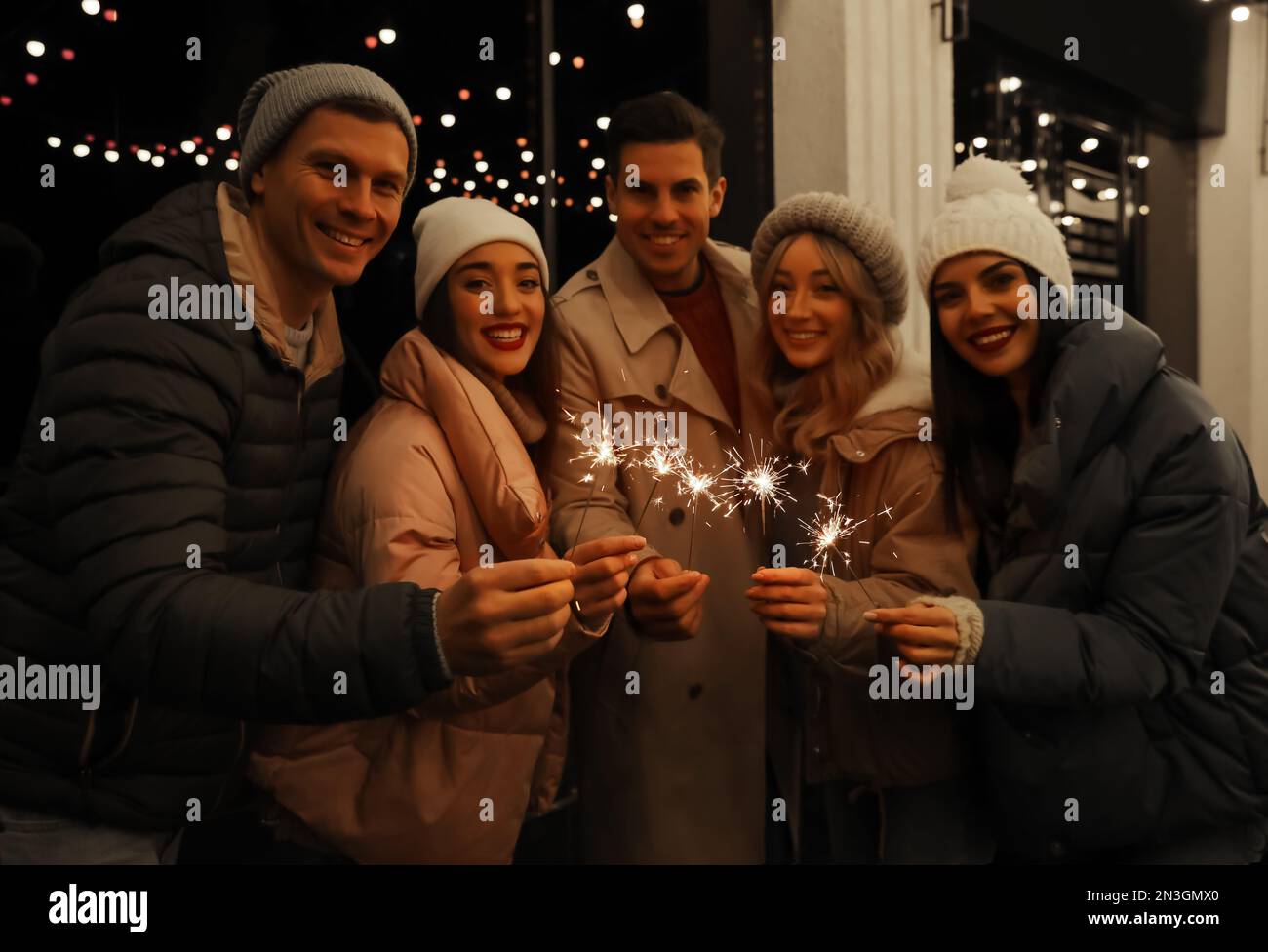 Group of people holding burning sparklers outdoors Stock Photo - Alamy