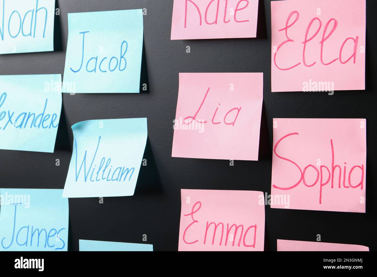 Sticky notes with baby names on black board, closeup Stock Photo - Alamy