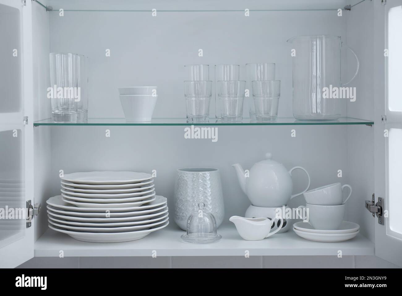 Cabinet with crockery and glassware. Order in kitchen Stock Photo - Alamy