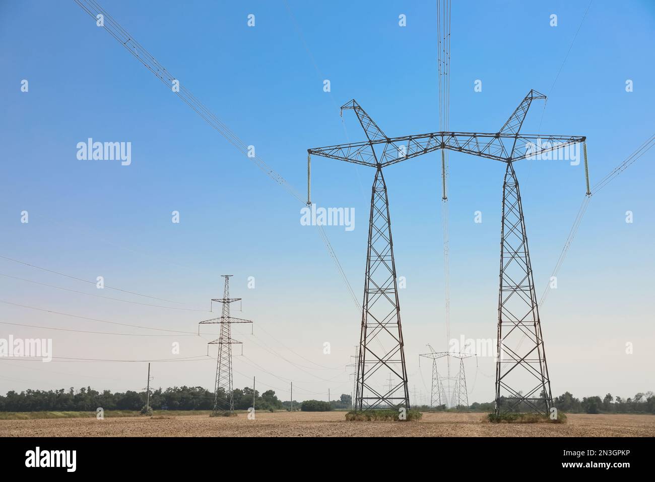 High voltage towers with electricity transmission power lines in field ...