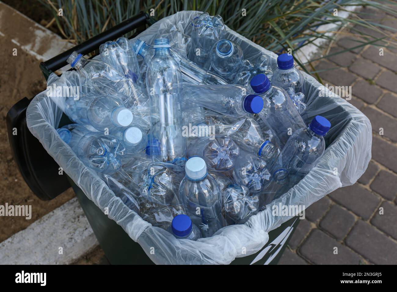 Many used plastic bottles in trash bin outdoors. Recycling problem ...