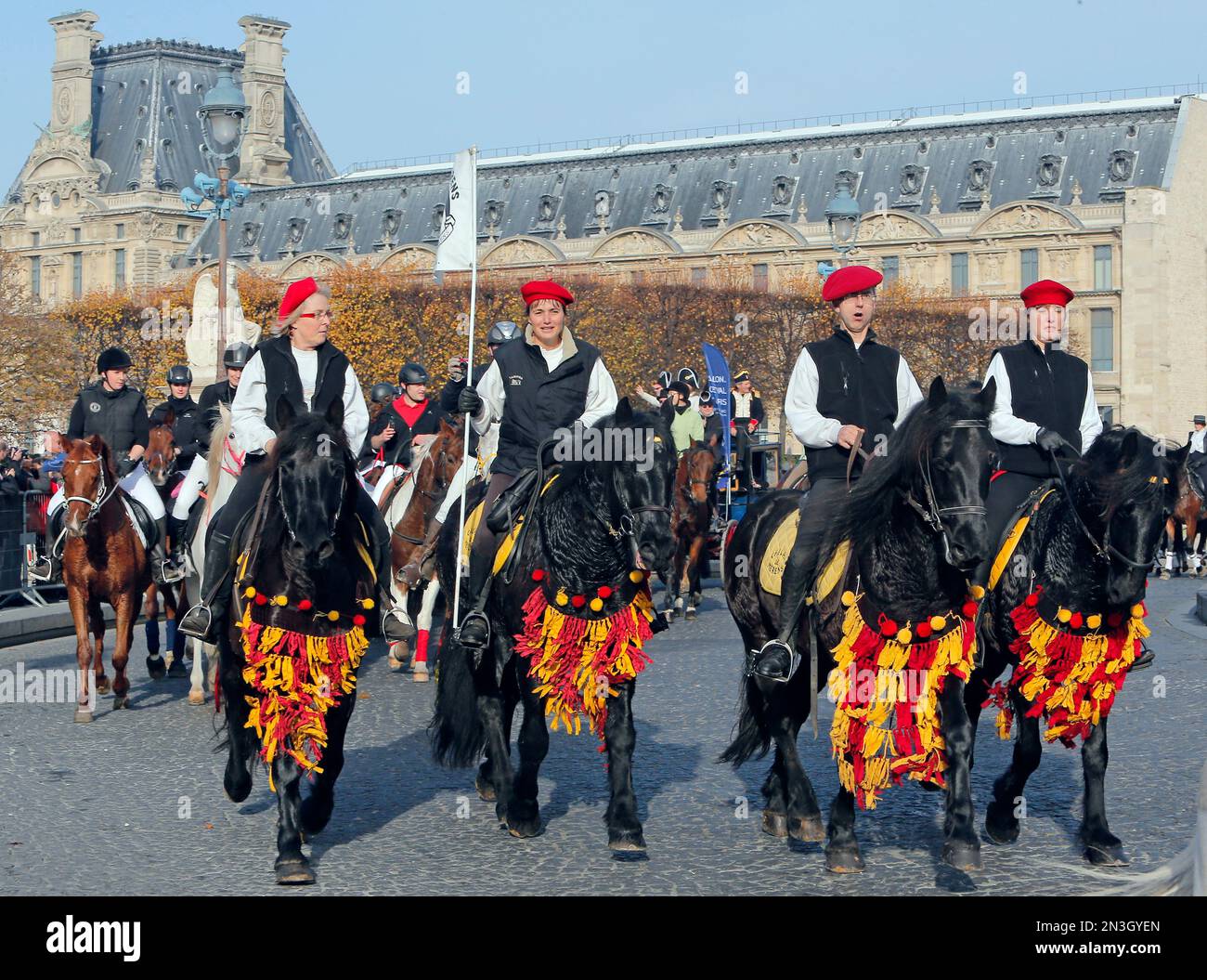 Riders pass in front of Le Louvre in Paris, Sunday Nov 23, 2014, during ...