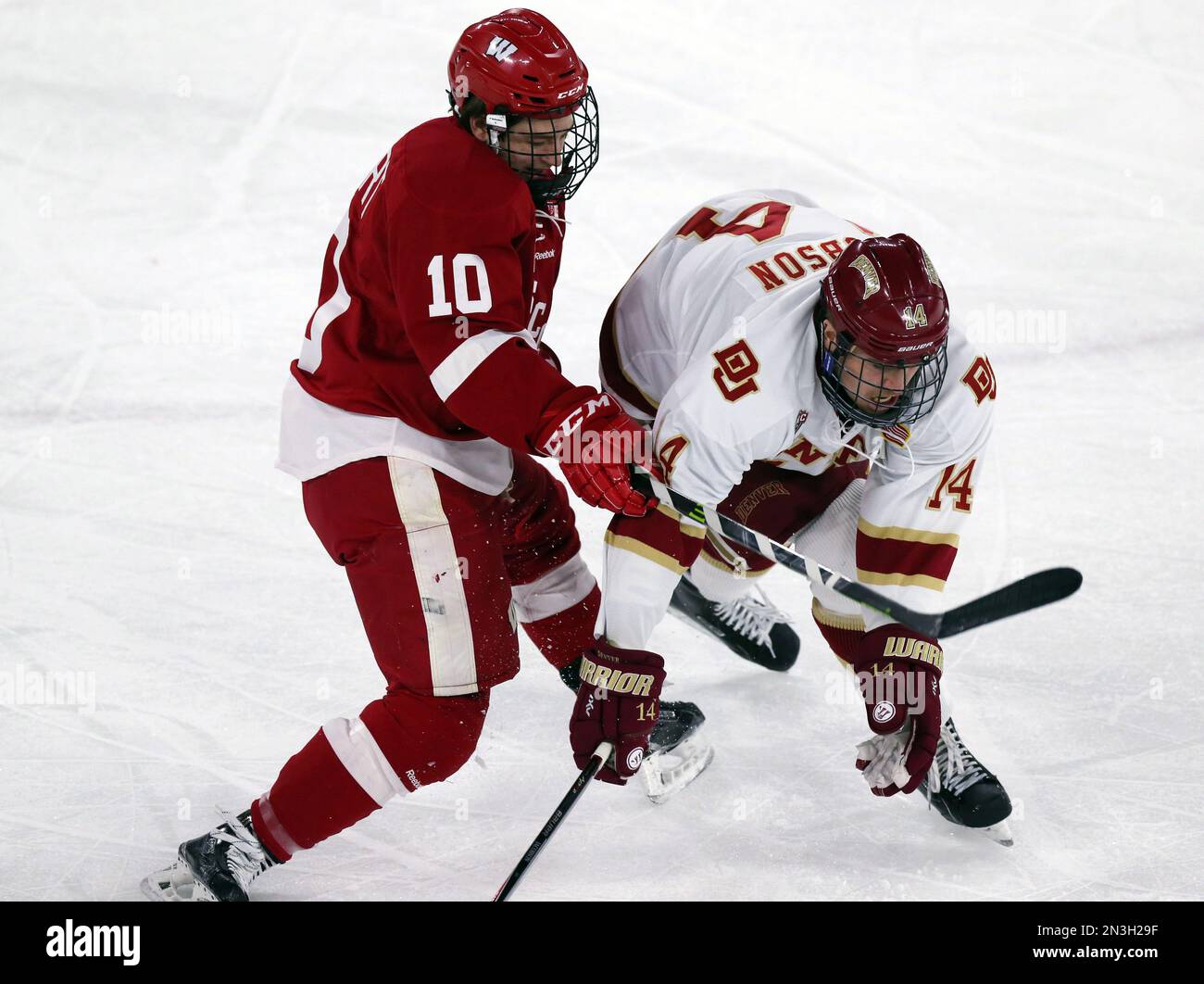 Wisconsin defenseman Jake Linhart, left, uses his stick to tangle up ...