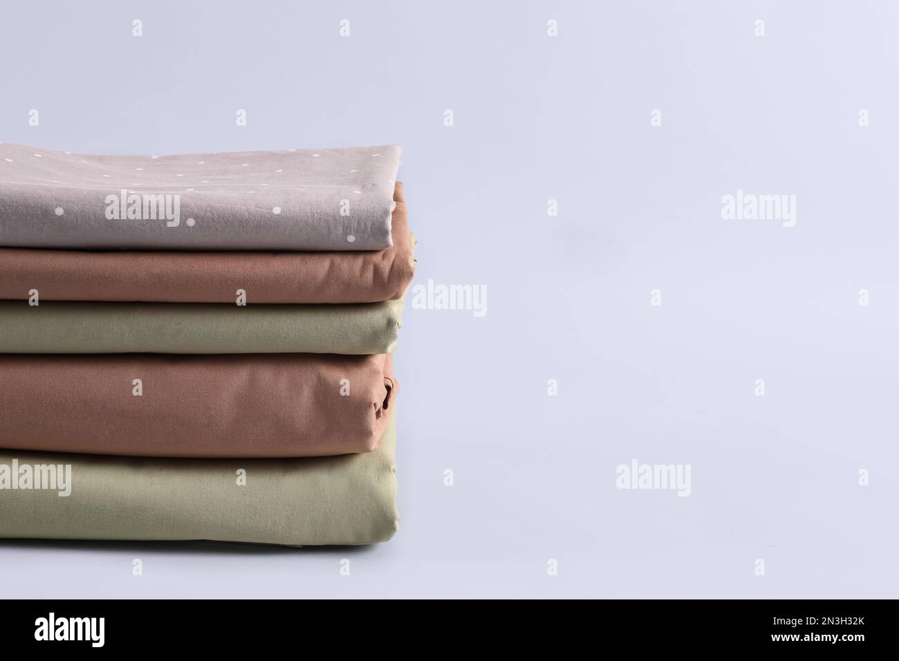 Stack of clean bed sheets on white background. Space for text Stock ...