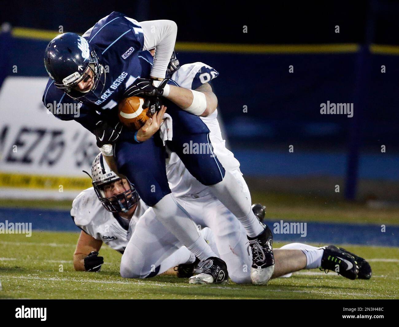 Maine quarterback Drew Belcher (14) gets sacked by New Hampshire ...