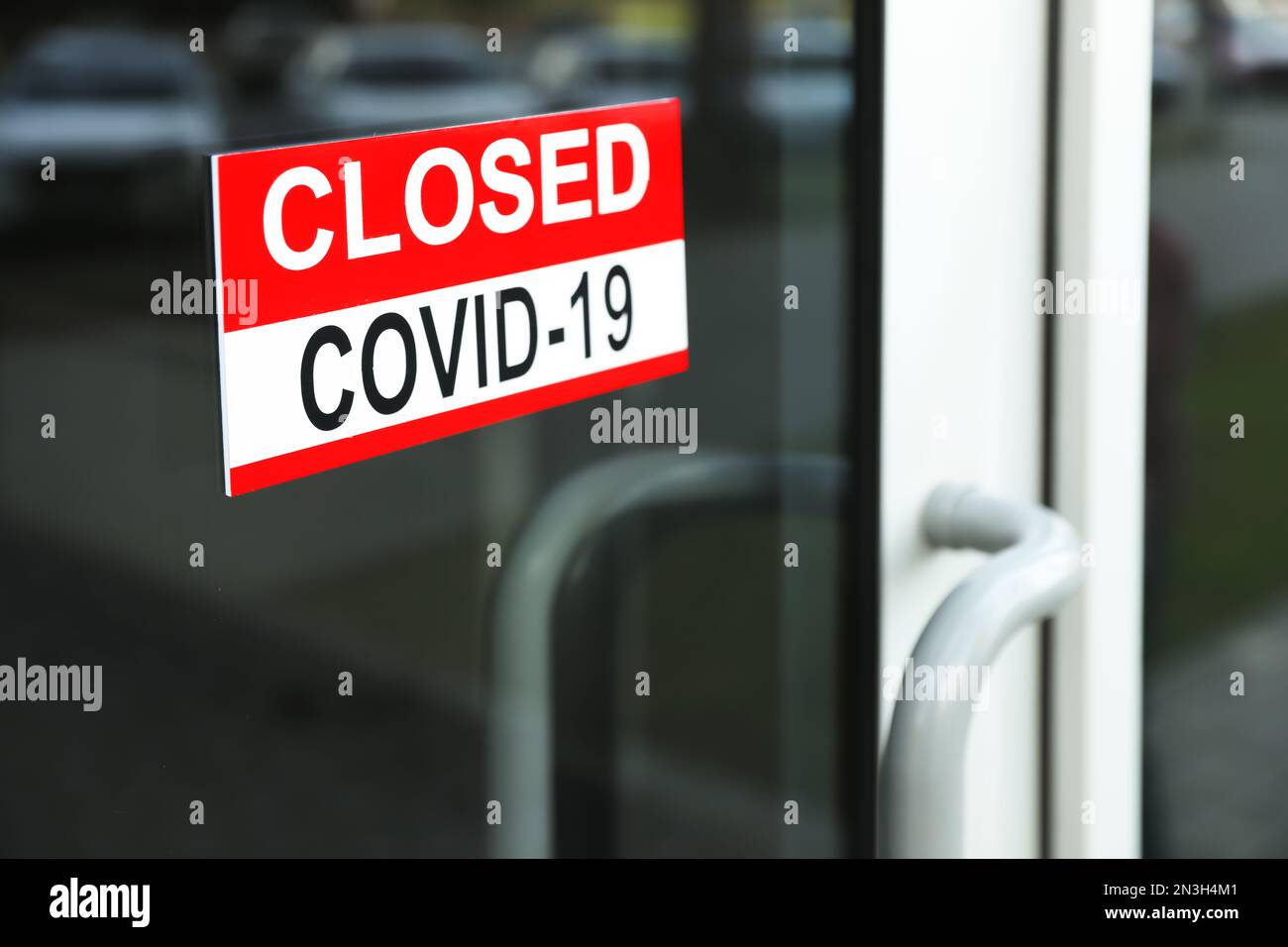 Red sign with words "Closed Covid-19" hanging on glass door Stock Photo ...