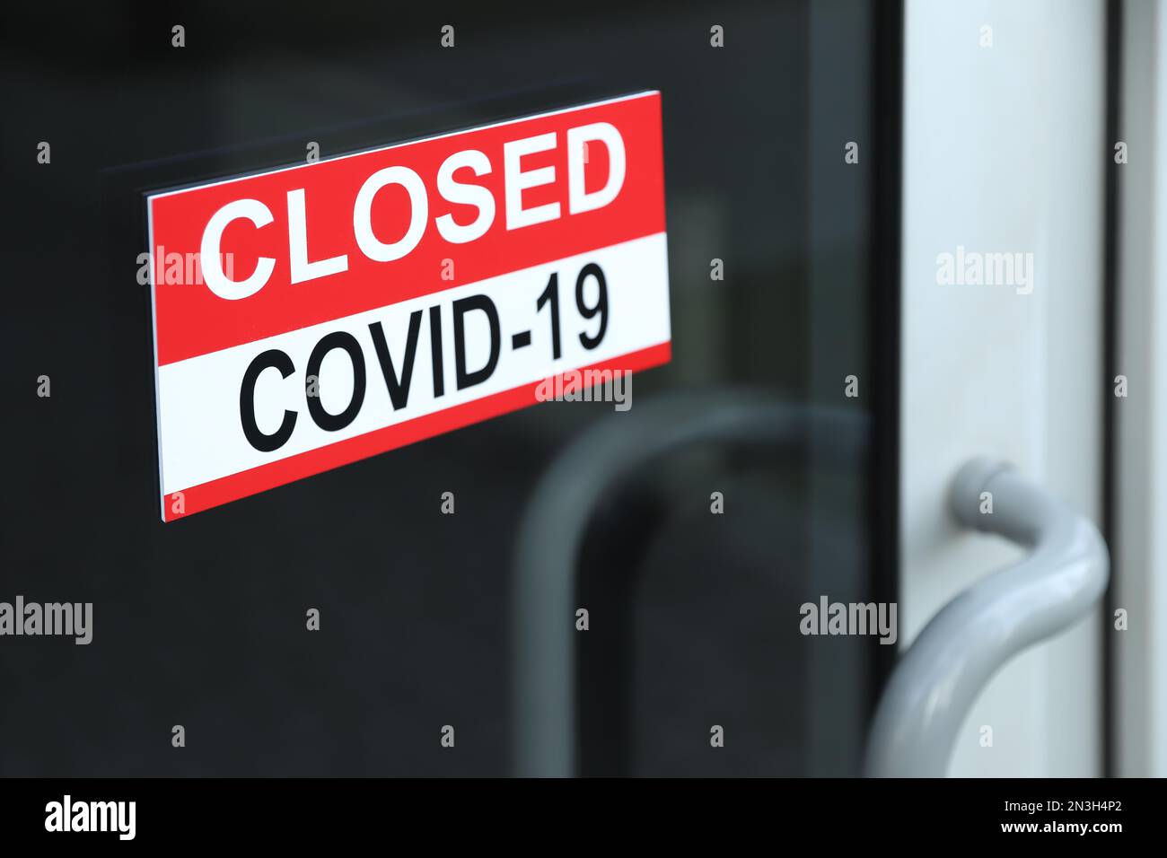 Red sign with words "Closed Covid-19" hanging on glass door Stock Photo ...