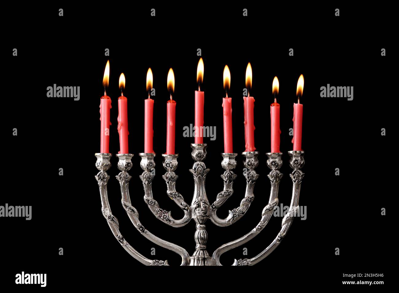 Silver menorah with burning candles against black background. Hanukkah ...