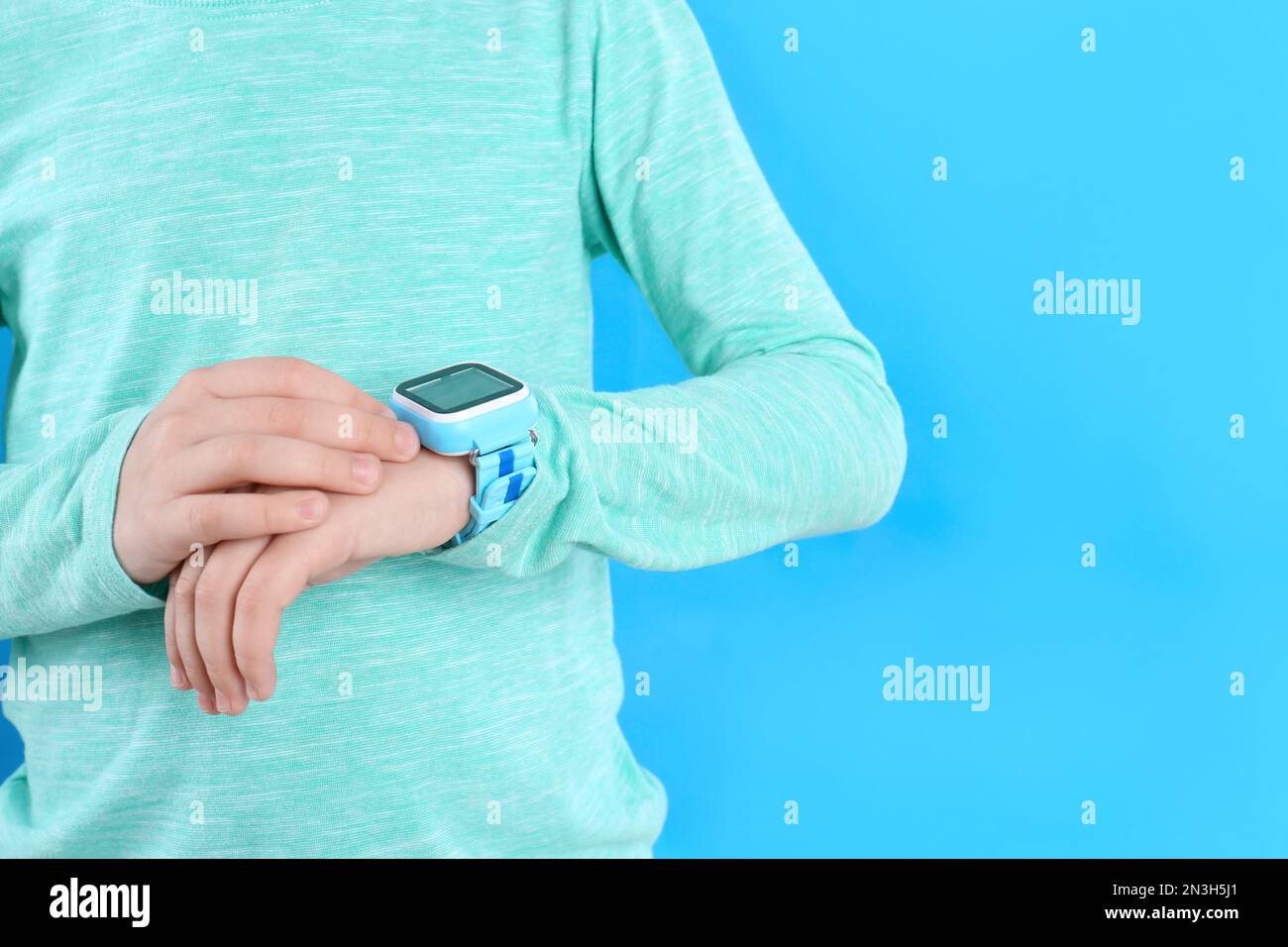 Boy with stylish smart watch on light blue background, closeup Stock ...