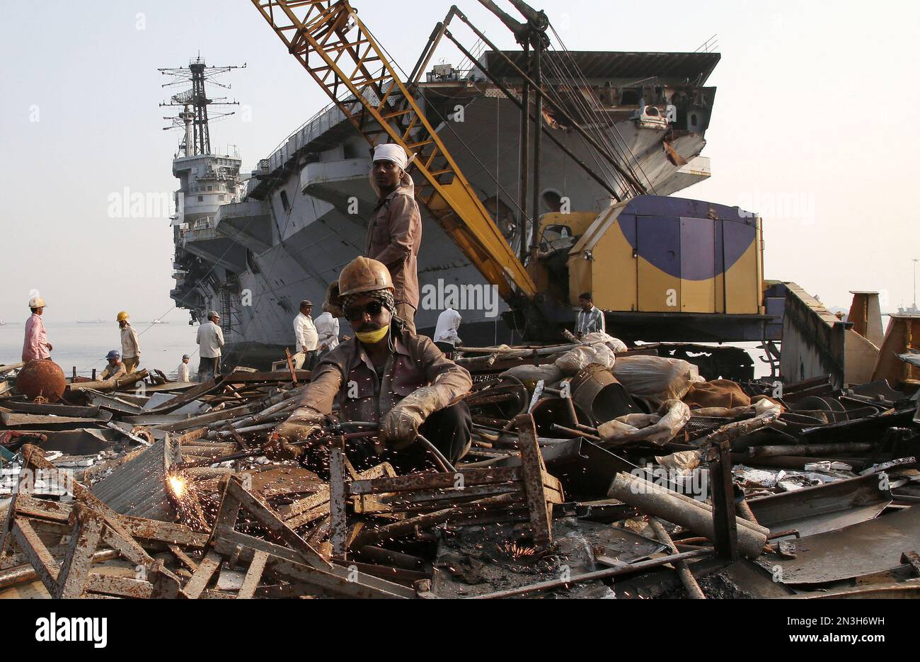 Workers dismantle India's first aircraft carrier INS Vikrant at a ship ...