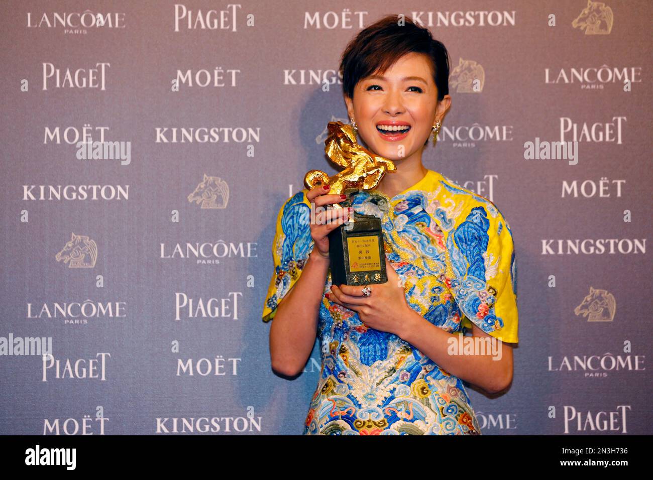 Taiwanese actress Regina Wan holds her awards and poses for media for ...
