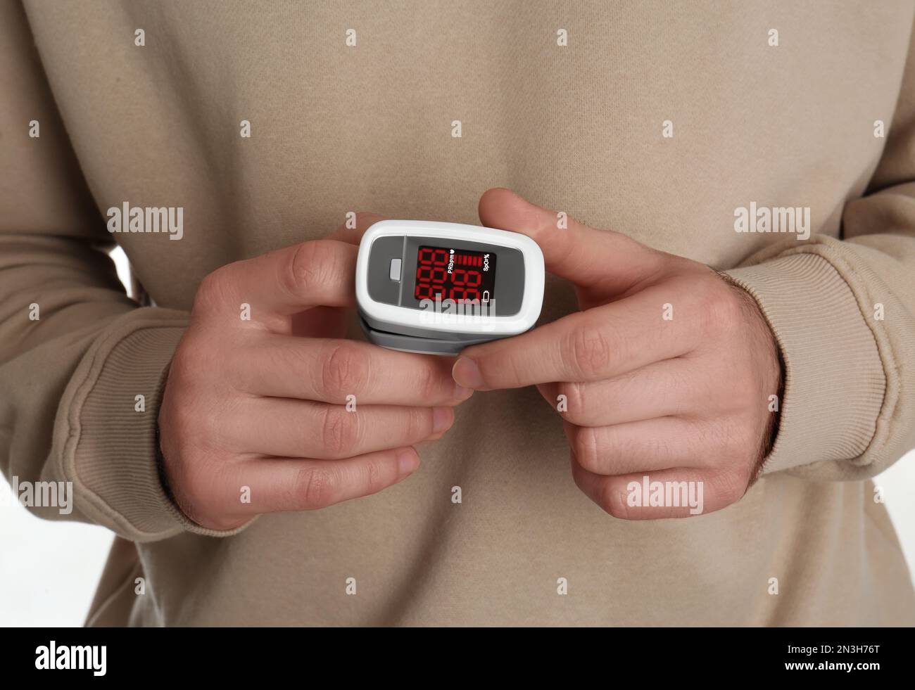 Man using pulse oximeter for oxygen level testing on white background ...