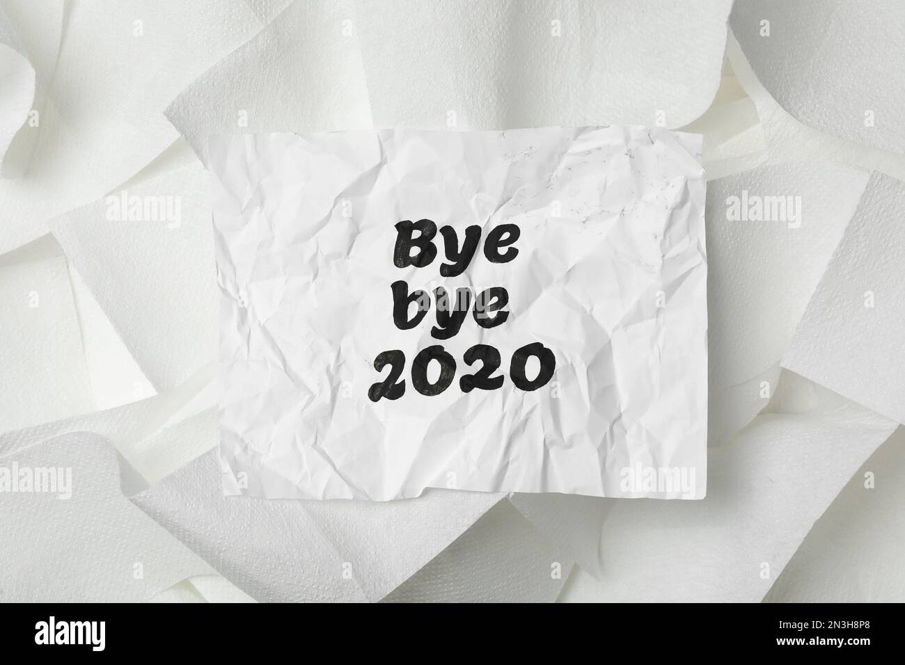 Crumpled sheet with text Bye Bye 2020 on pile of toilet paper, top view ...