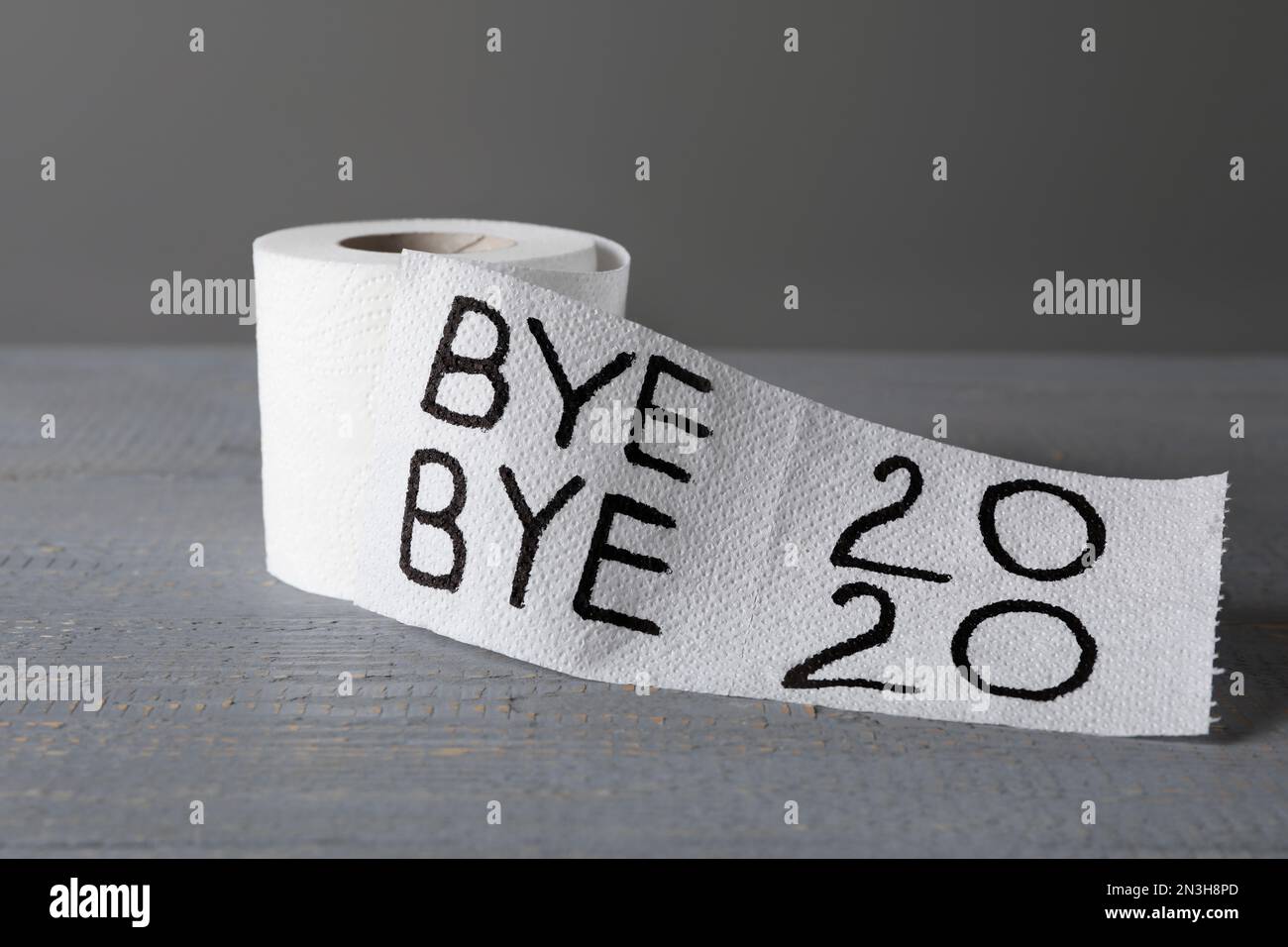 Toilet paper roll with text Bye Bye 2020 on light grey wooden ...
