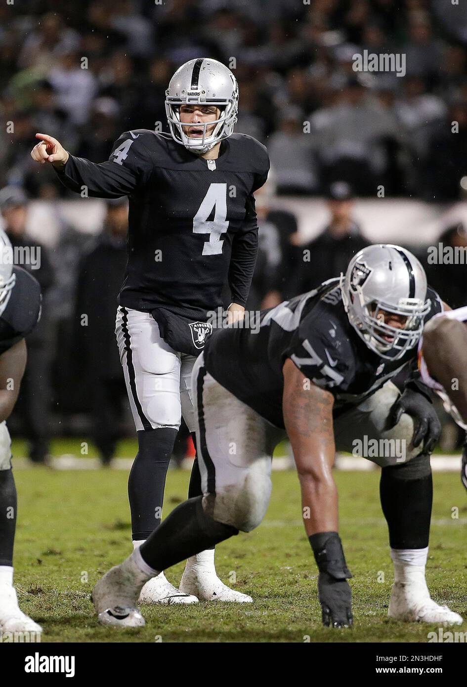 Oakland Raiders quarterback Derek Carr (4) signals behind tackle Austin ...