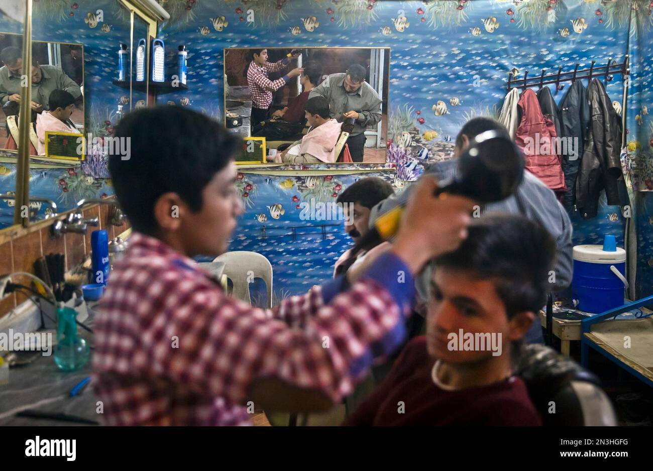 People get haircuts in a barber shop in Suruc, on the Turkey-Syria ...