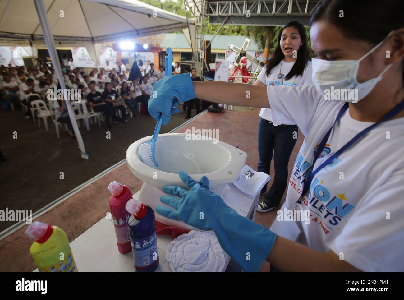 A Filipino woman demonstrates how to clean a toilet bowl at a poor ...