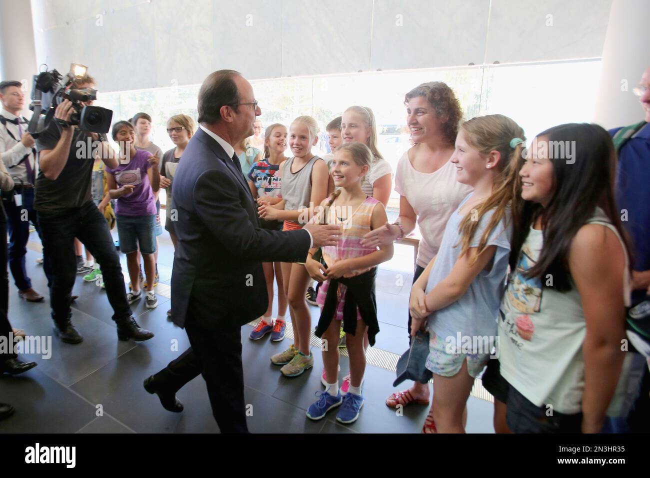French President Francios Hollande, center left, greets crowds gathered ...