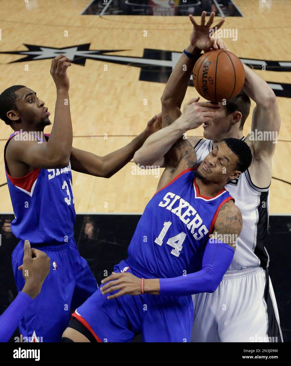 San Antonio Spurs' Aron Baynes, right, battles Philadelphia 76ers' K.J ...