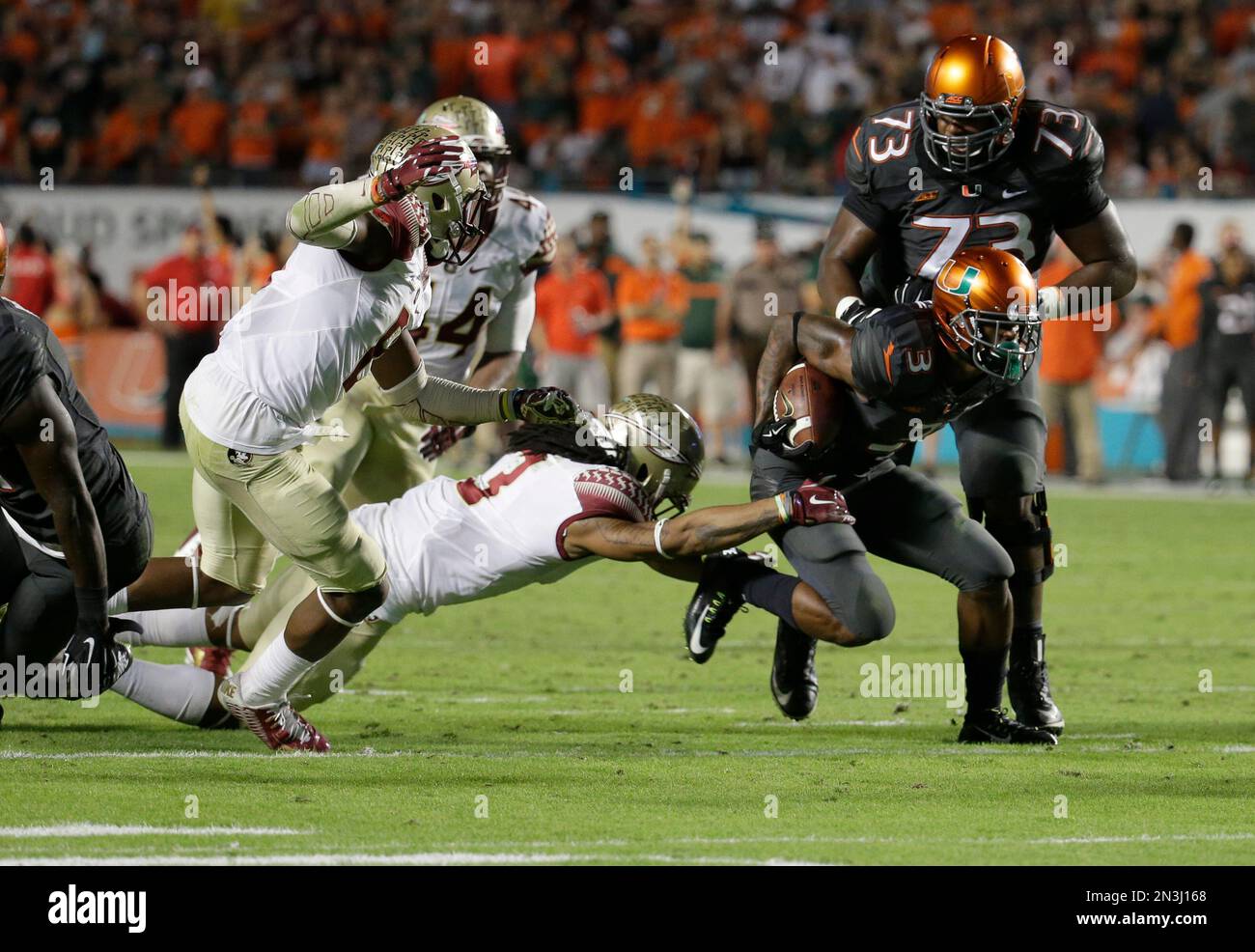 Miami wide receiver Stacy Coley, right, runs as he is tackled by ...