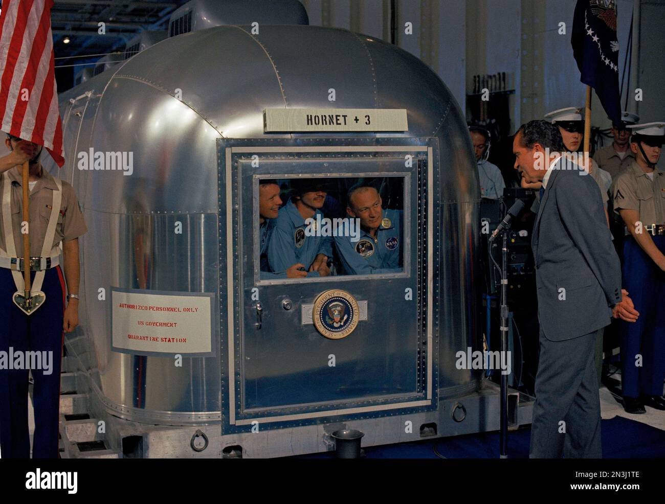 President Nixon looks at the Apollo 11 astronauts in the isolation unit ...