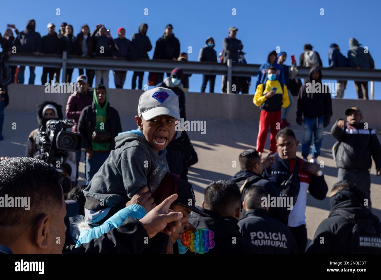Juarez, Mexico, 11-27-2022: A migrant carries his son on his shoulders ...