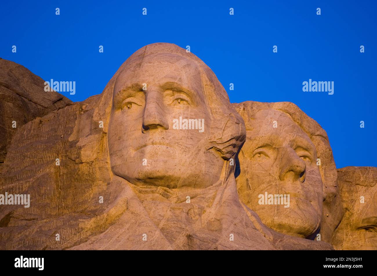 Mount Rushmore at sunrise, with the faces of George Washington and ...